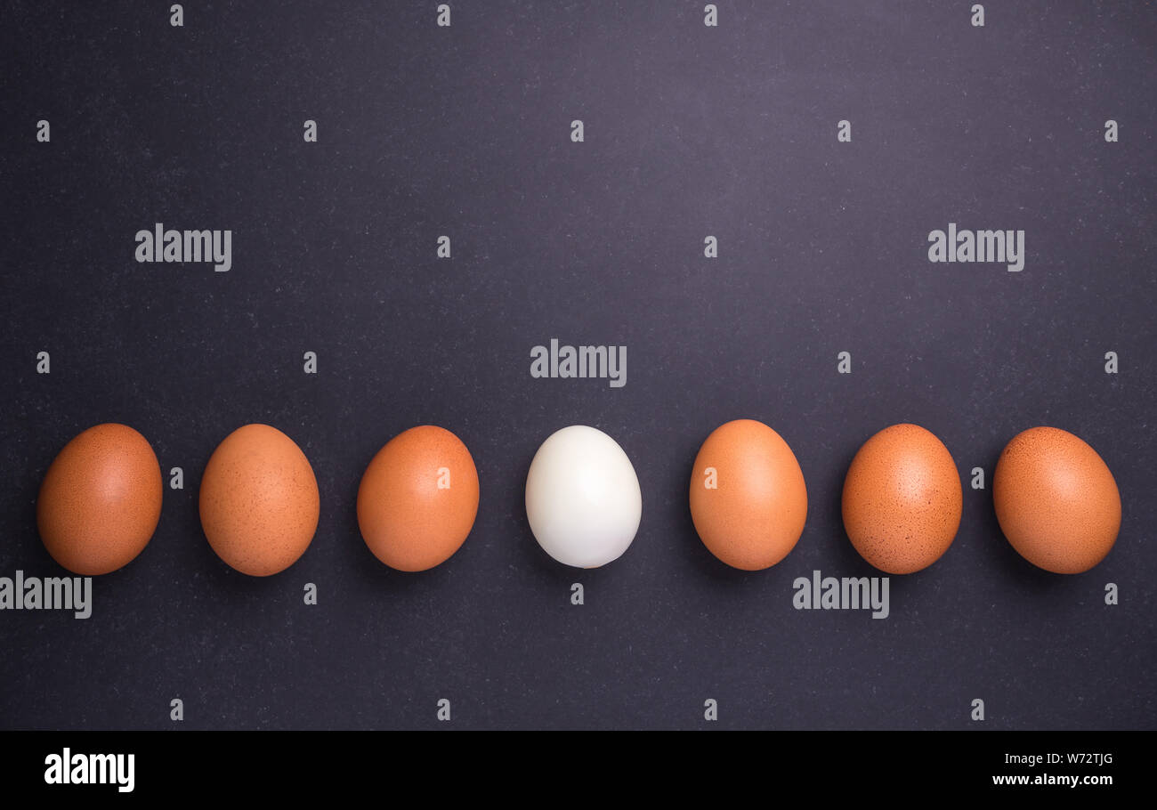 Fresh egg and boiled egg without shell. Top view on black stone ...