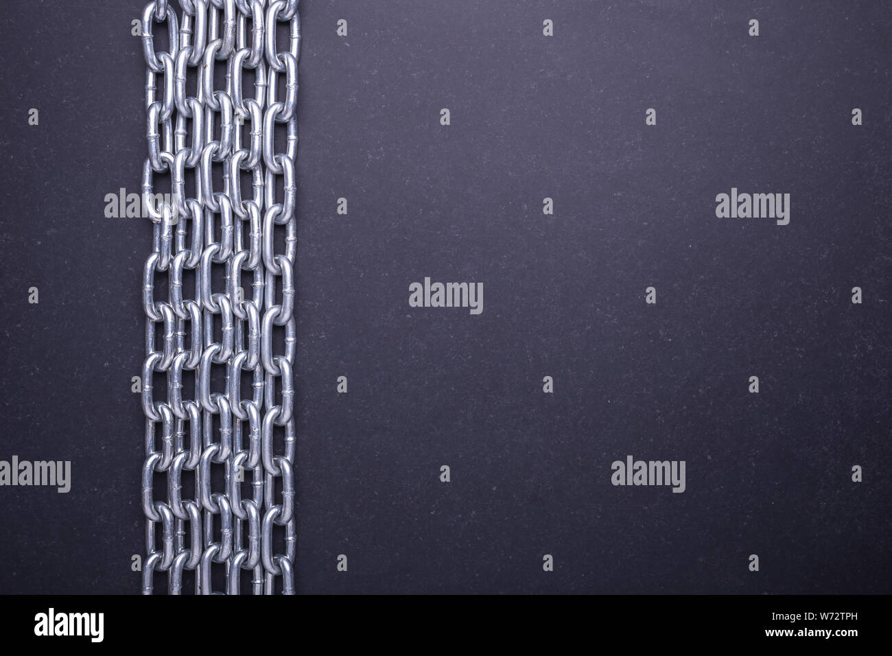 New silver metal chain. Top view on black stone background Stock Photo ...