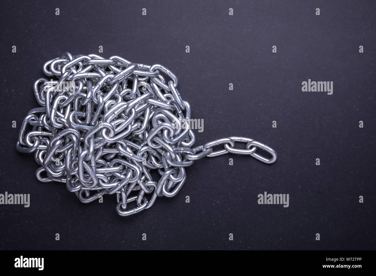 New silver metal chain. Top view on black stone background Stock Photo ...