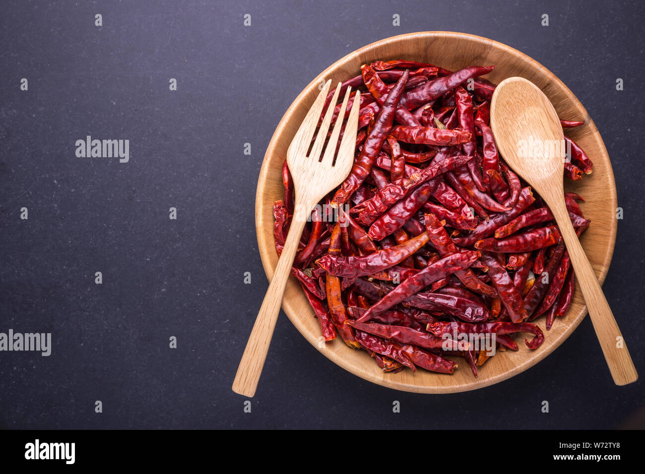 Top view dry red hot chilli on black stone board background. Eating ...