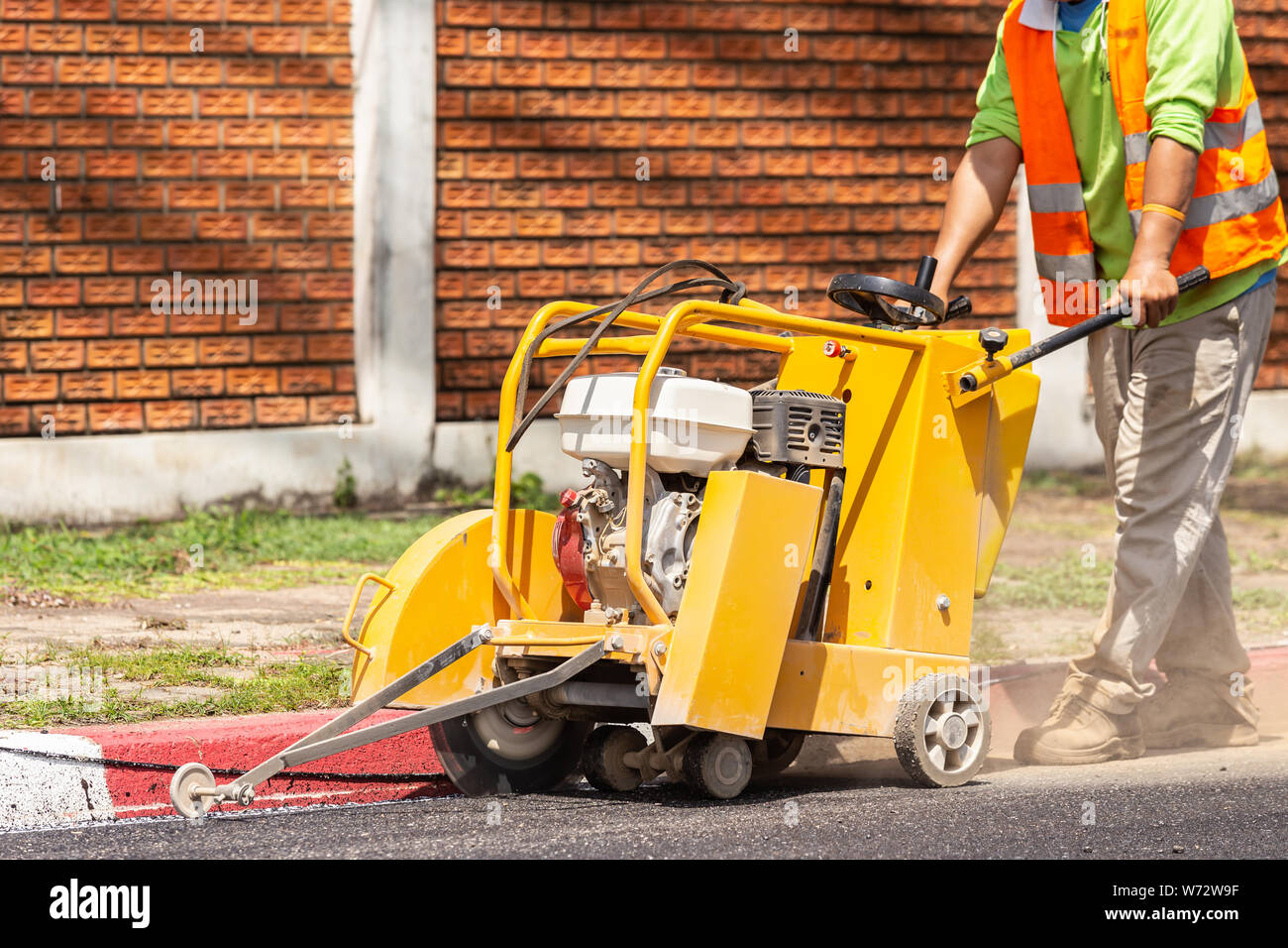 Outdoor working : Worker using machine to cut the asphalt road. Process ...