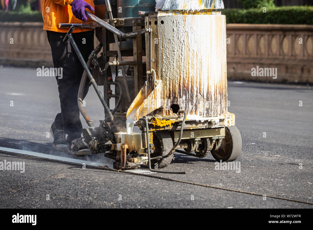 Outdoor working : Man using machine to make traffic line stripe on the ...