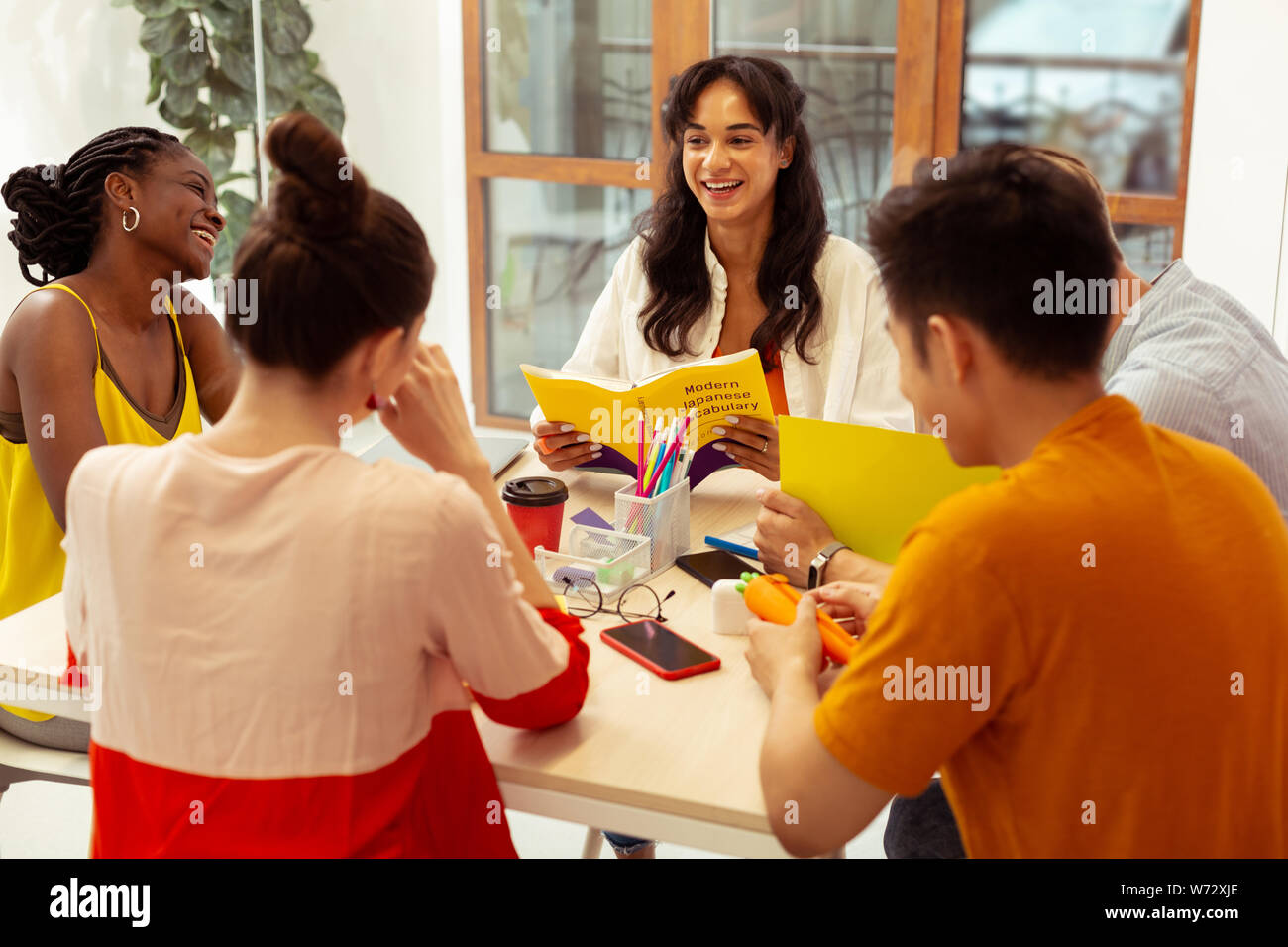 Group of cheerful students studying in language school Stock Photo - Alamy