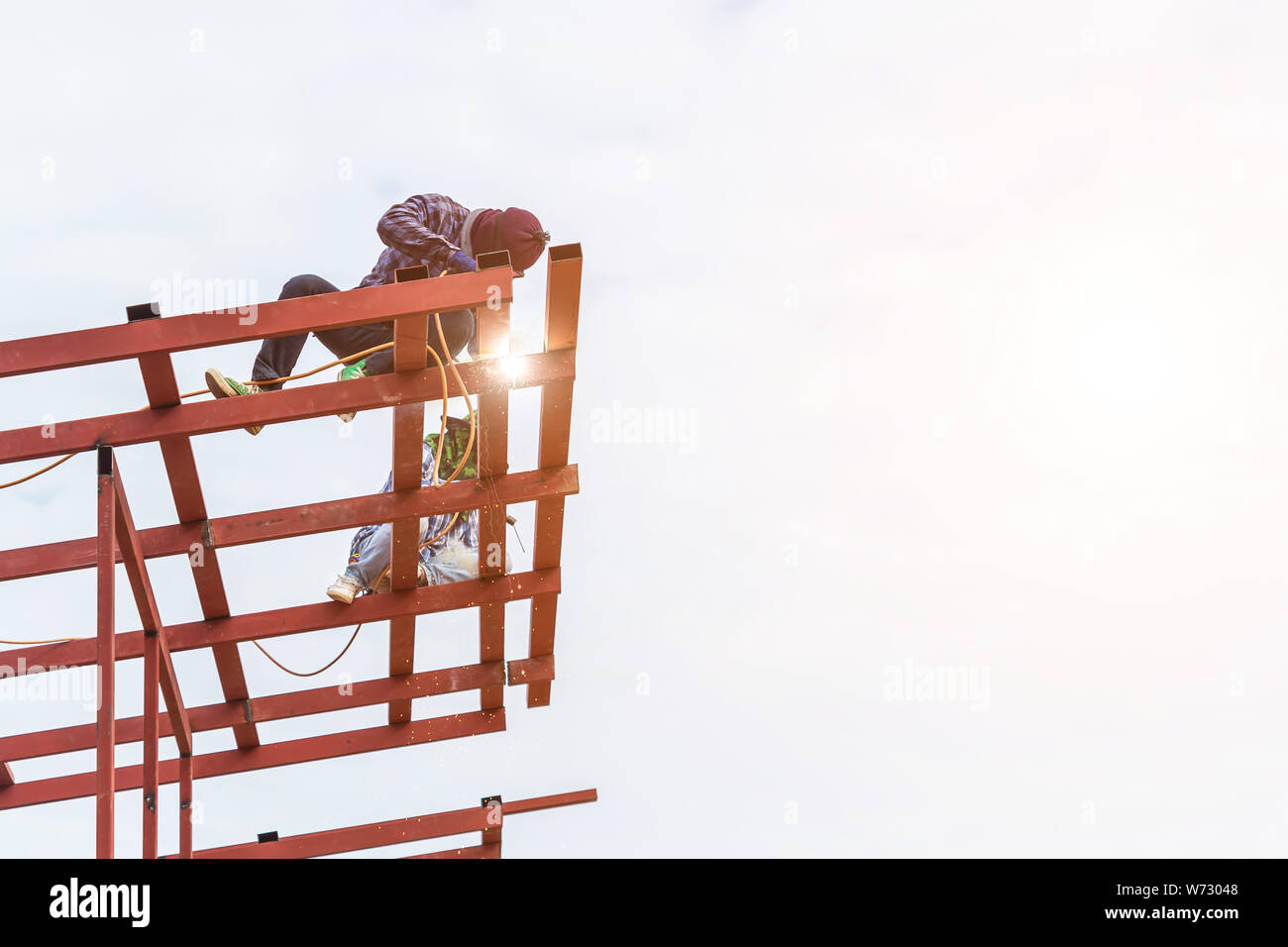 Construction worker welding steel for roof structure in process of ...