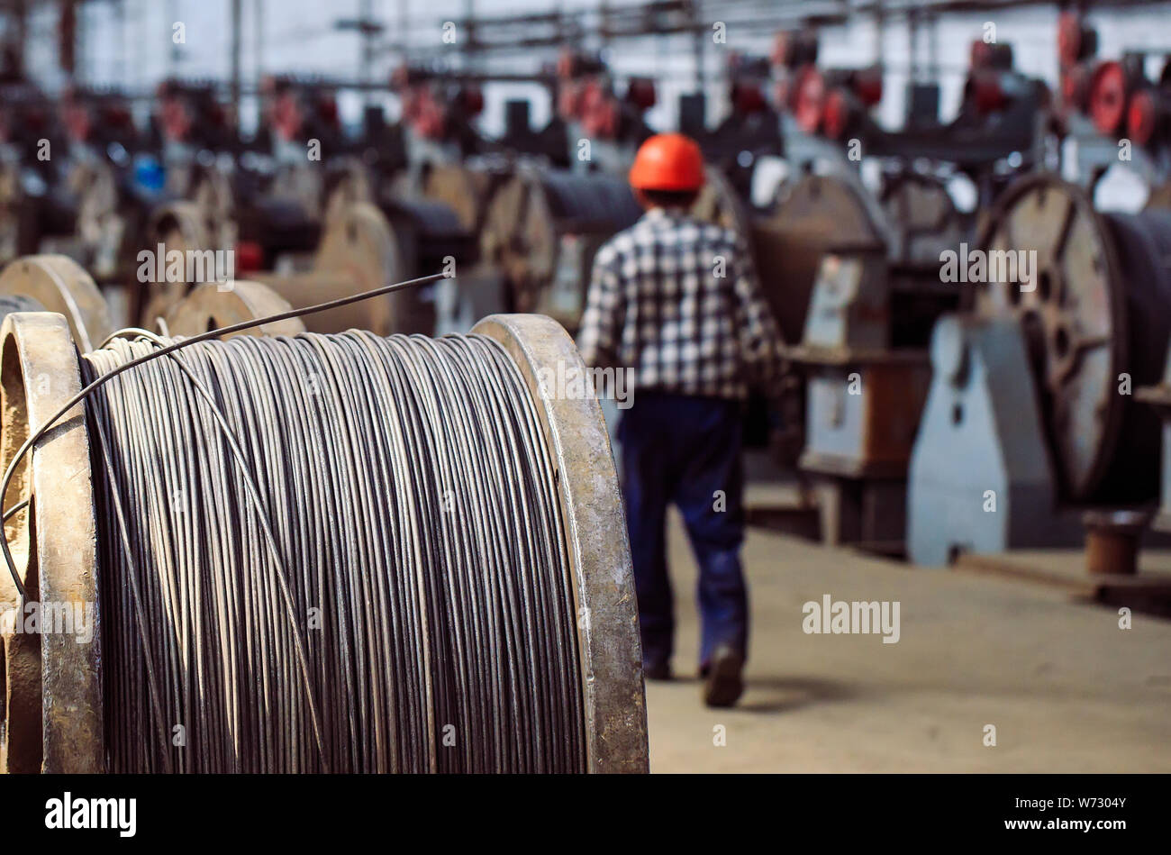 Wire rod, fittings in warehouses. worker alongside a bundle with ...