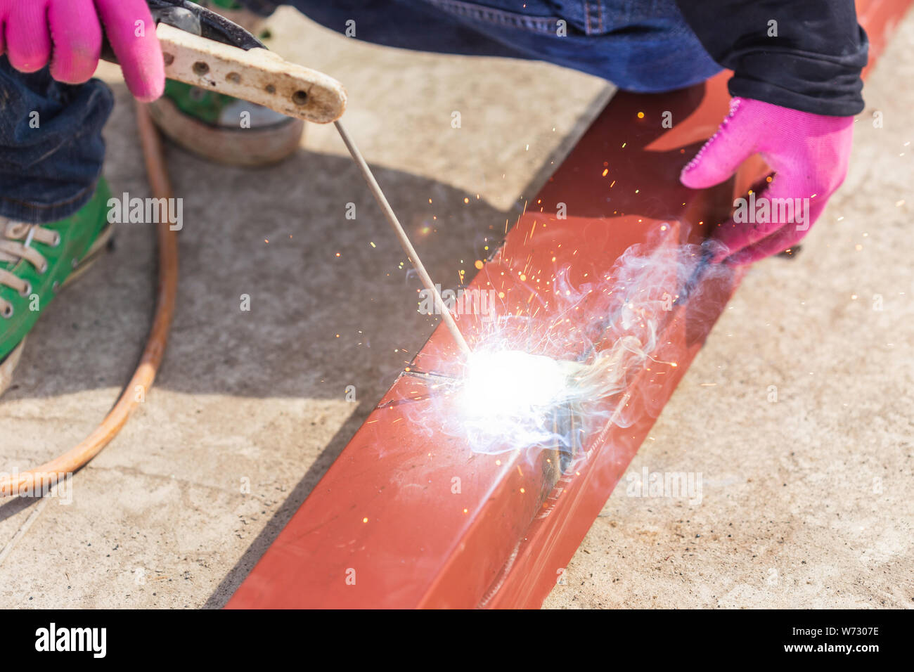 Construction worker welding steel for roof structure in process of ...