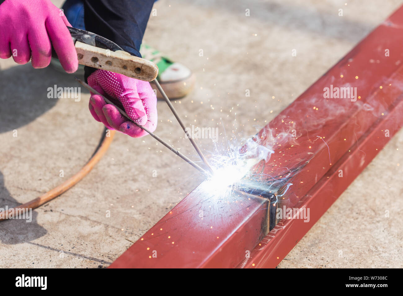 Construction worker welding steel for roof structure in process of ...