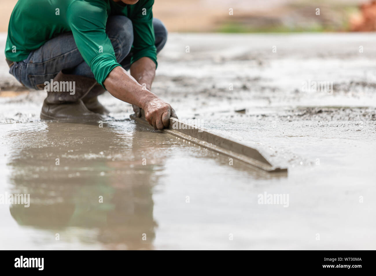 Work industrial concept : Pouring and sweep the wet cement on the floor ...