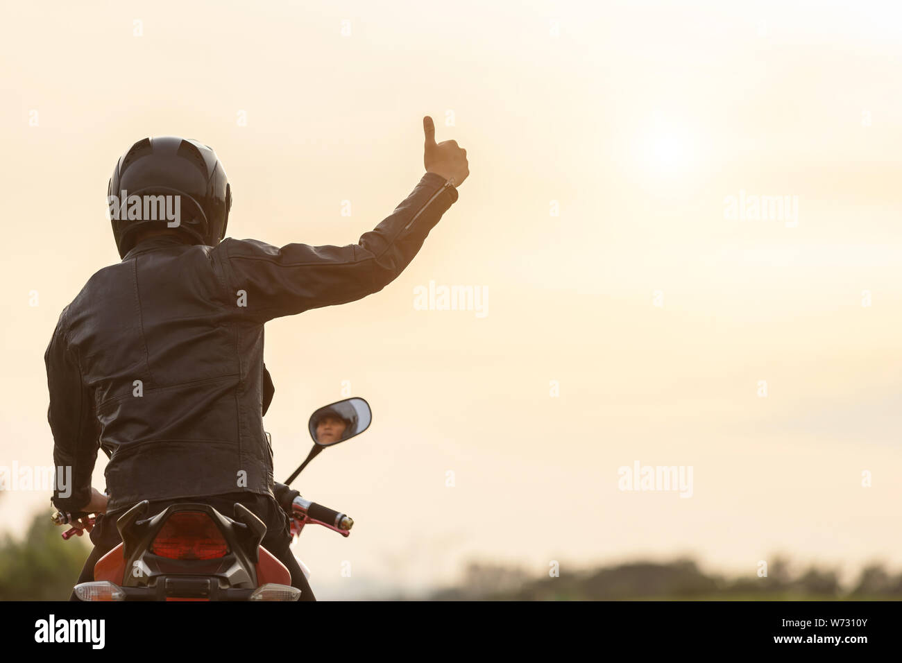 Handsome motorcyclist wear leather jacket and holding helmet on the ...