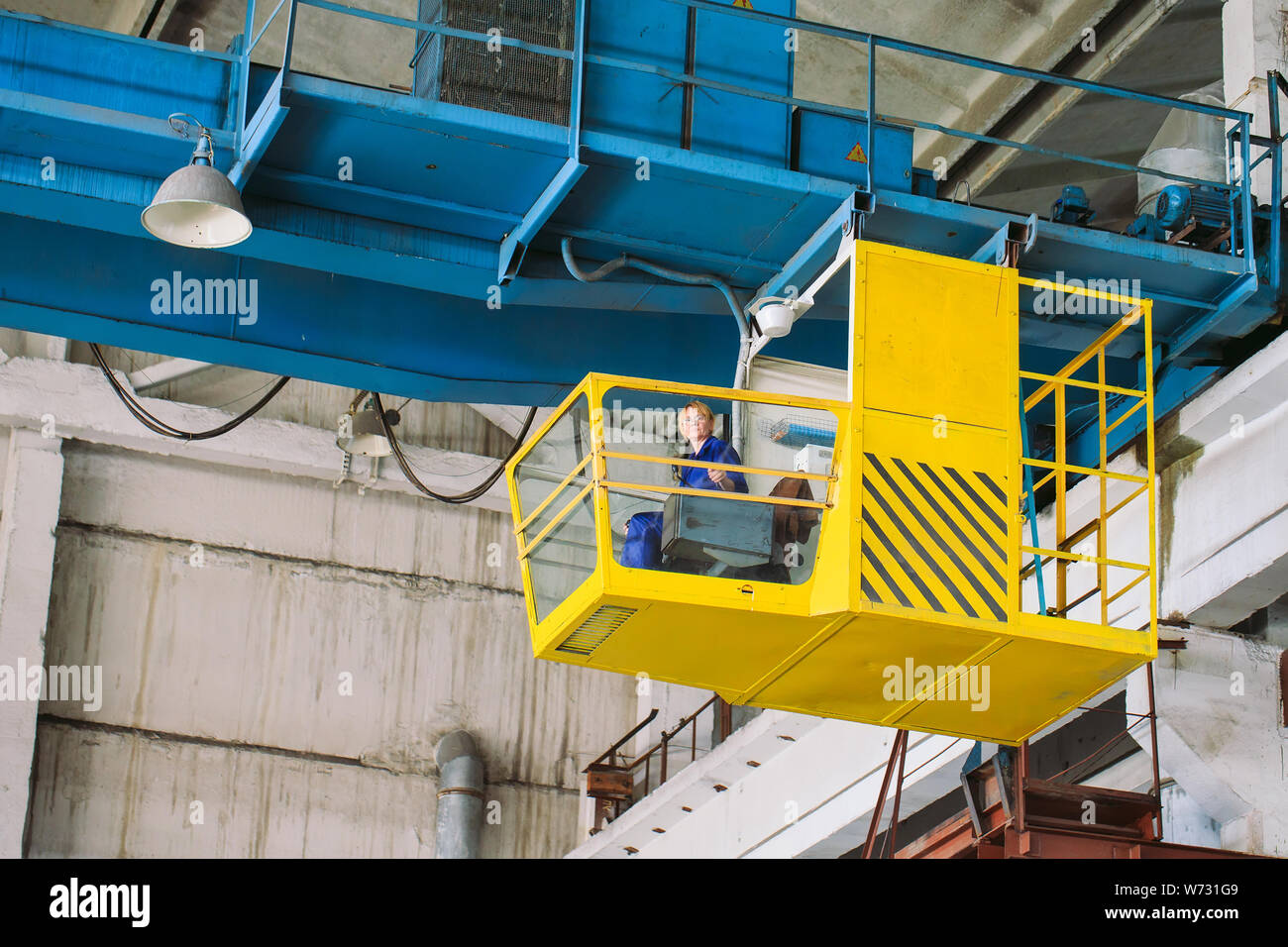 The girl working in the cab of a crane. Heavy industry, metal factory ...