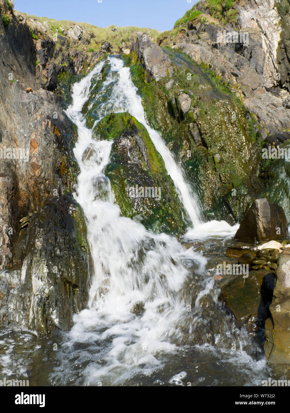 Small stream flowing down the cliff onto the beach at Welcombe Mouth ...
