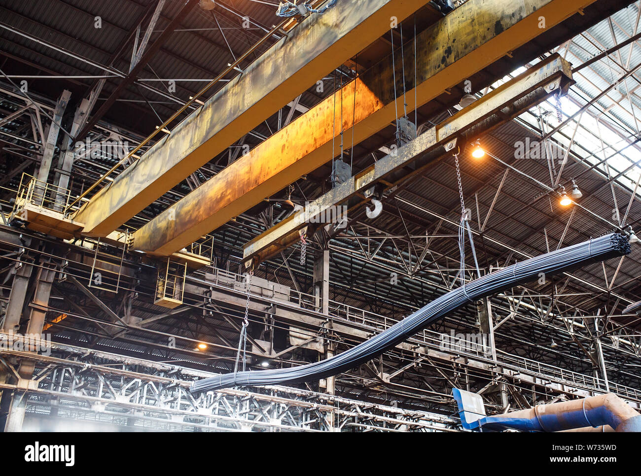 Crane loader carries rebar and wire rod in the factory Stock Photo - Alamy
