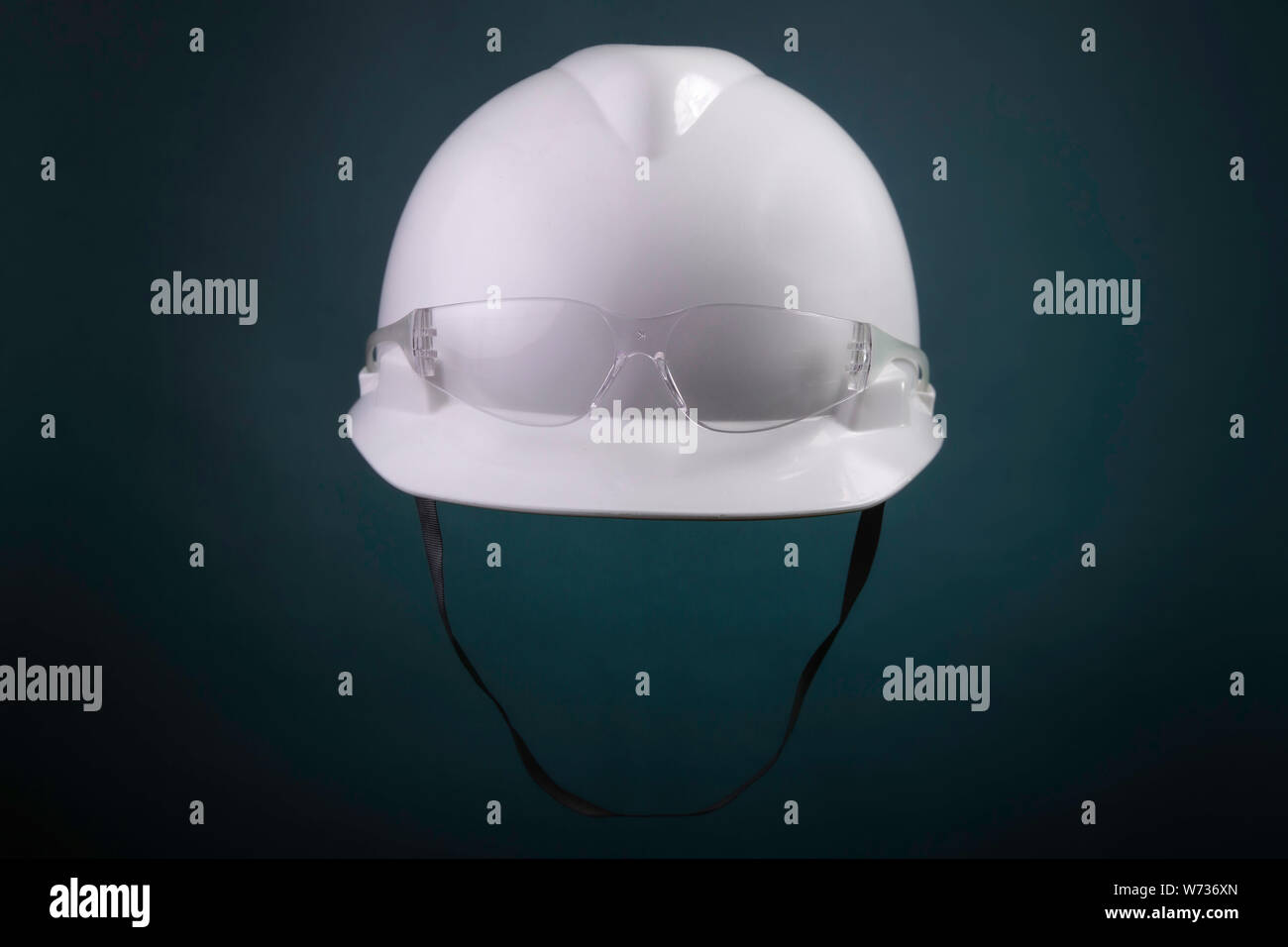 White generic protective construction helmet with strap and plastic ...