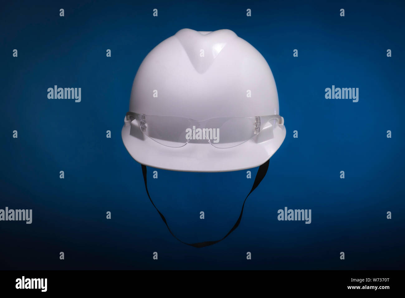 White generic protective construction helmet with strap and plastic ...