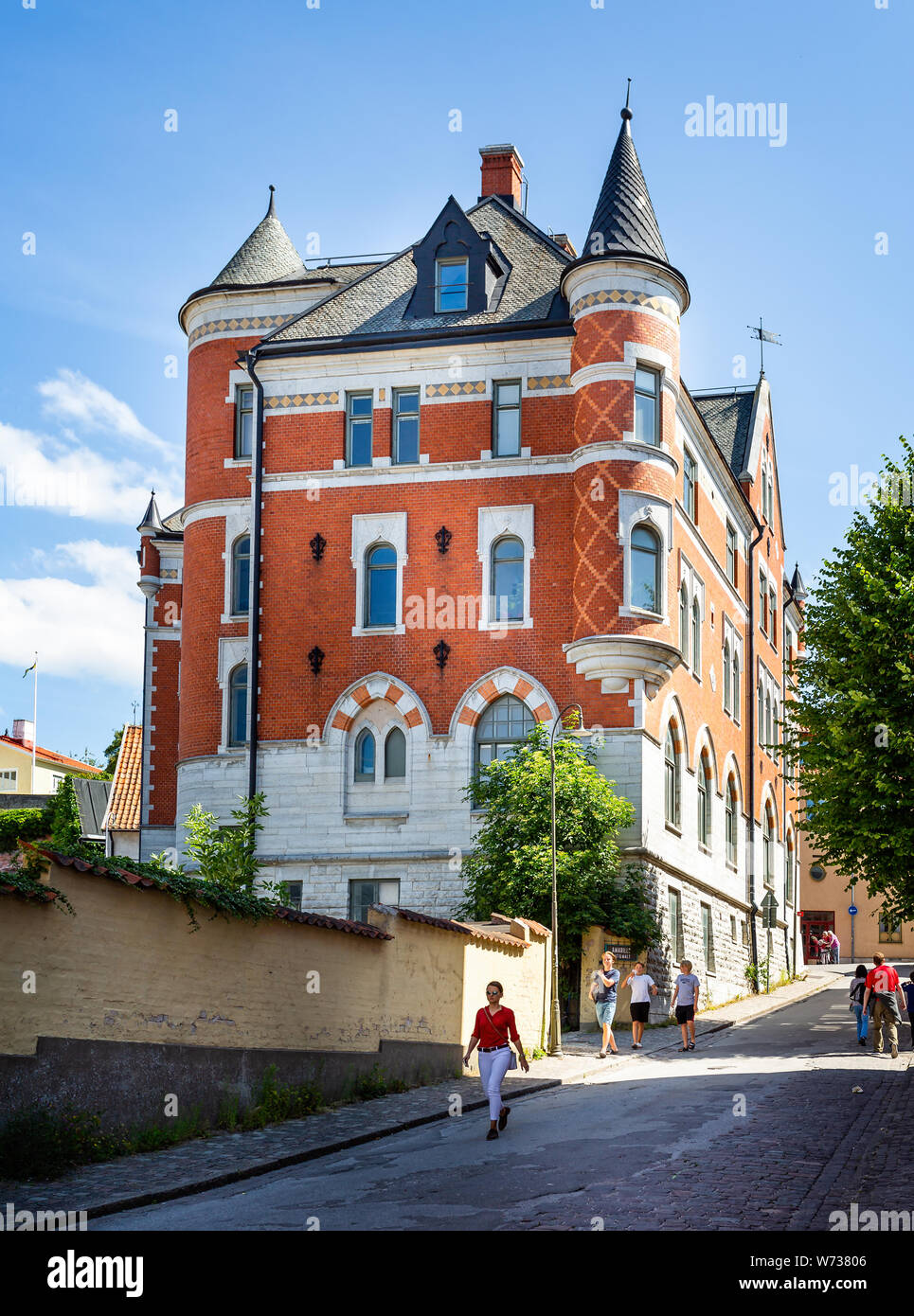 Ornate red brick building with turrets in centre of medieval Visby ...