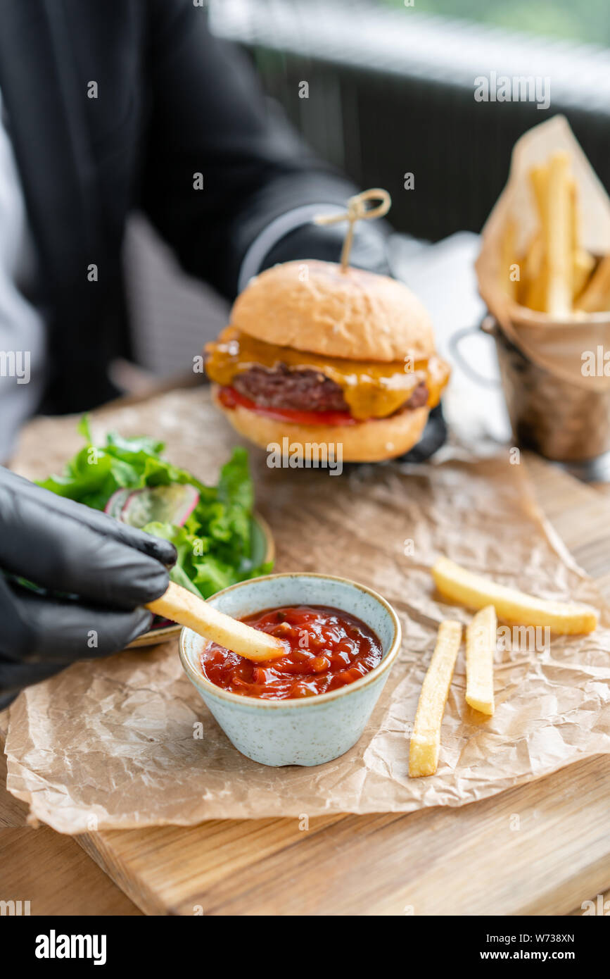 Young man in business suit and black gloves eating delicious juicy ...