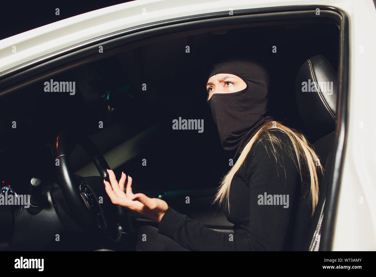 Masked robber woman car The thief is levering the lock at the door car ...