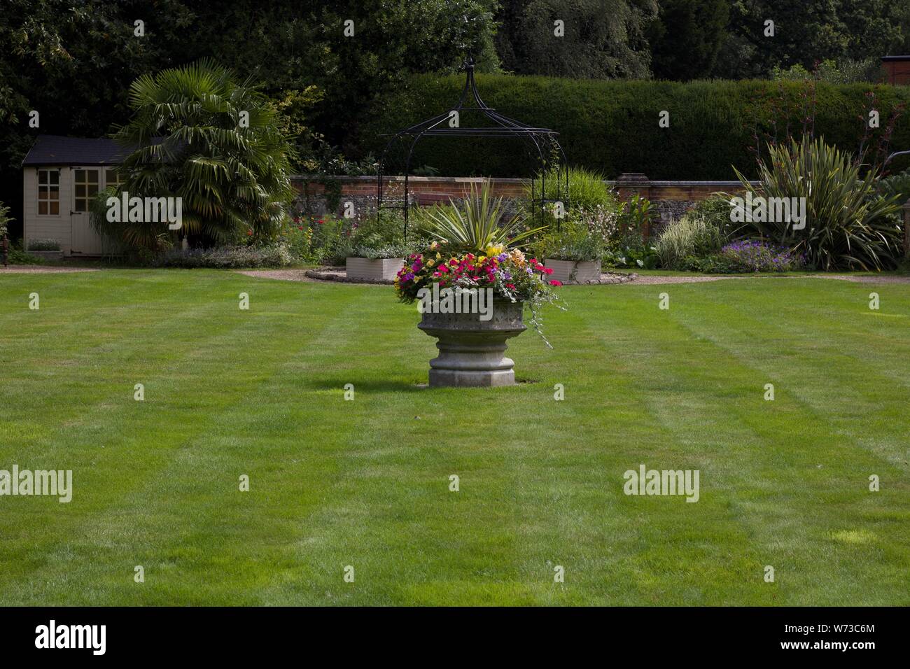 Formal English country garden with planter on lawn Stock Photo - Alamy