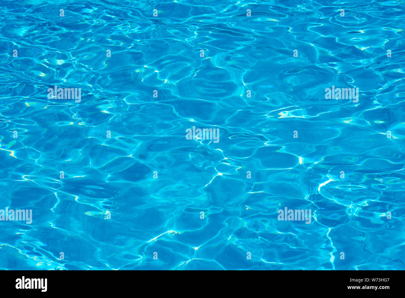Background of water in blue swimming pool, water surface with sun ...