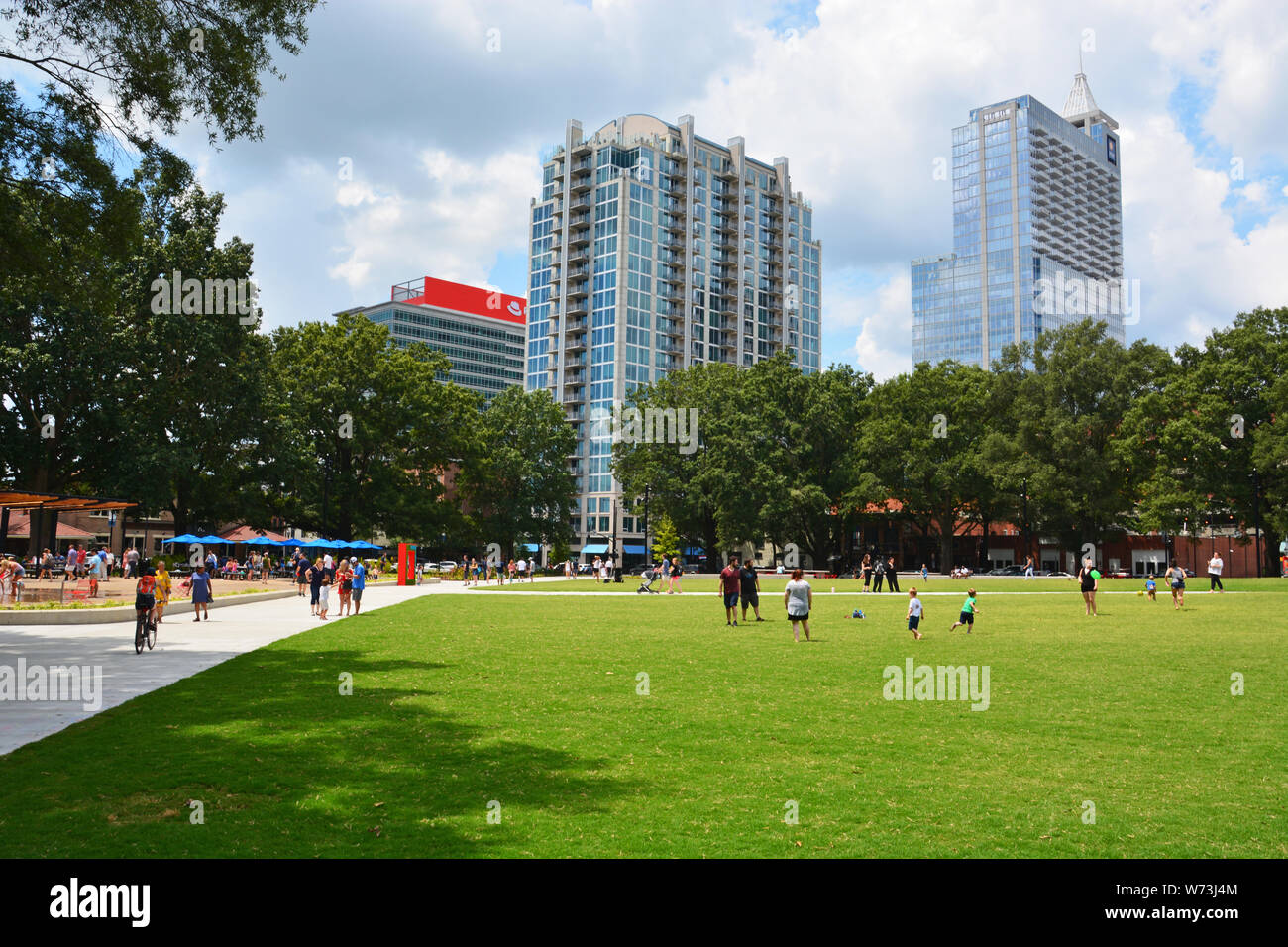 Buildings in downtown Raleigh NC rise up over the trees and the lawn in ...