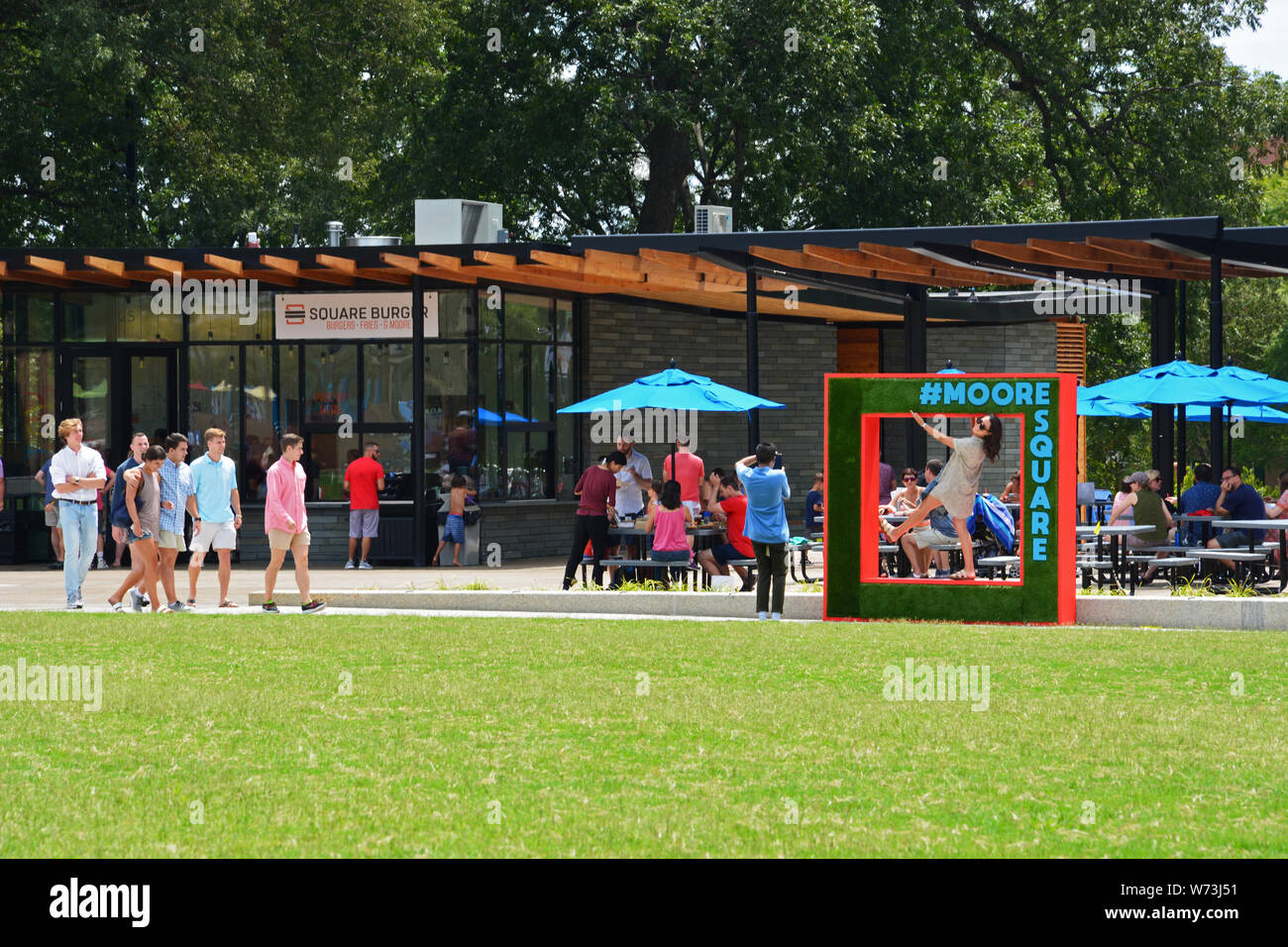 Visitors pose for pictures at the sign in Moore Square. The downtown ...