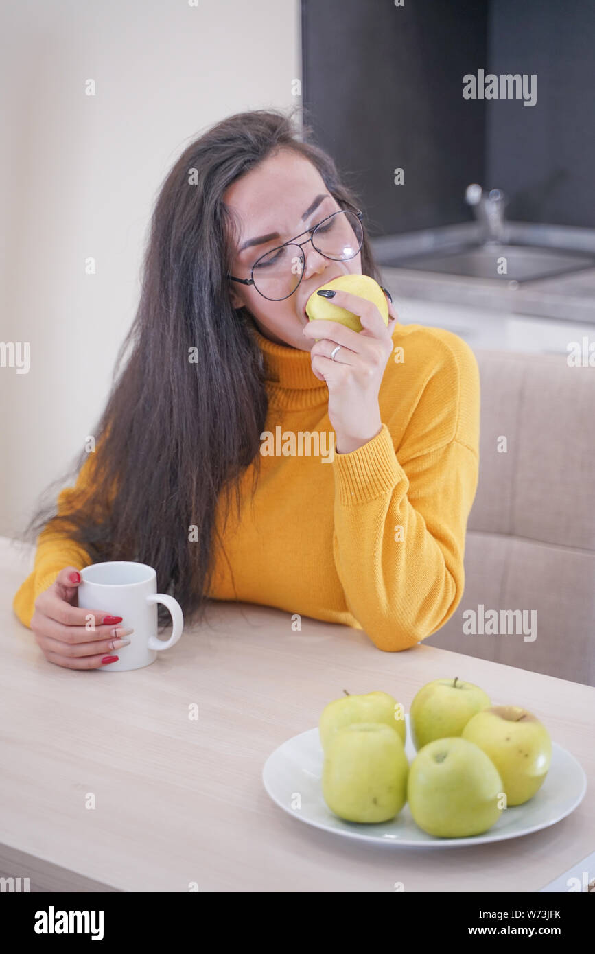 Close up portrait of a lovely pretty girl biting an apple in white ...