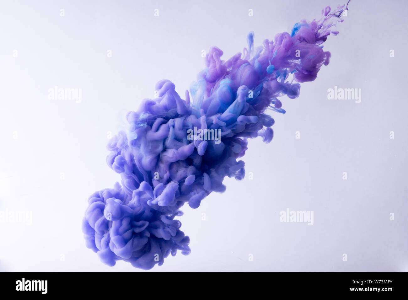 Colorful Ink swirling in water. Cloud of silky ink on white background ...