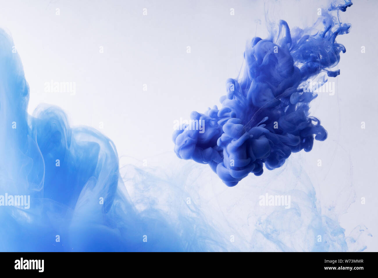 Colorful Ink swirling in water. Cloud of silky ink on white background ...