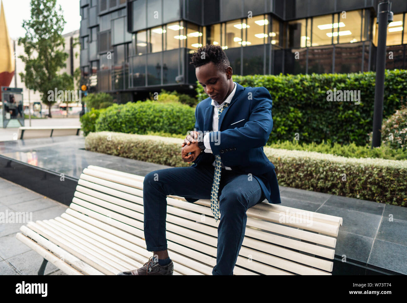 Businessman looking at his watch in office Stock Photo - Alamy