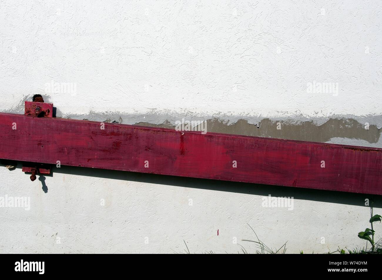 Protective red plank wooden barrier half fallen off the wall. No idea ...