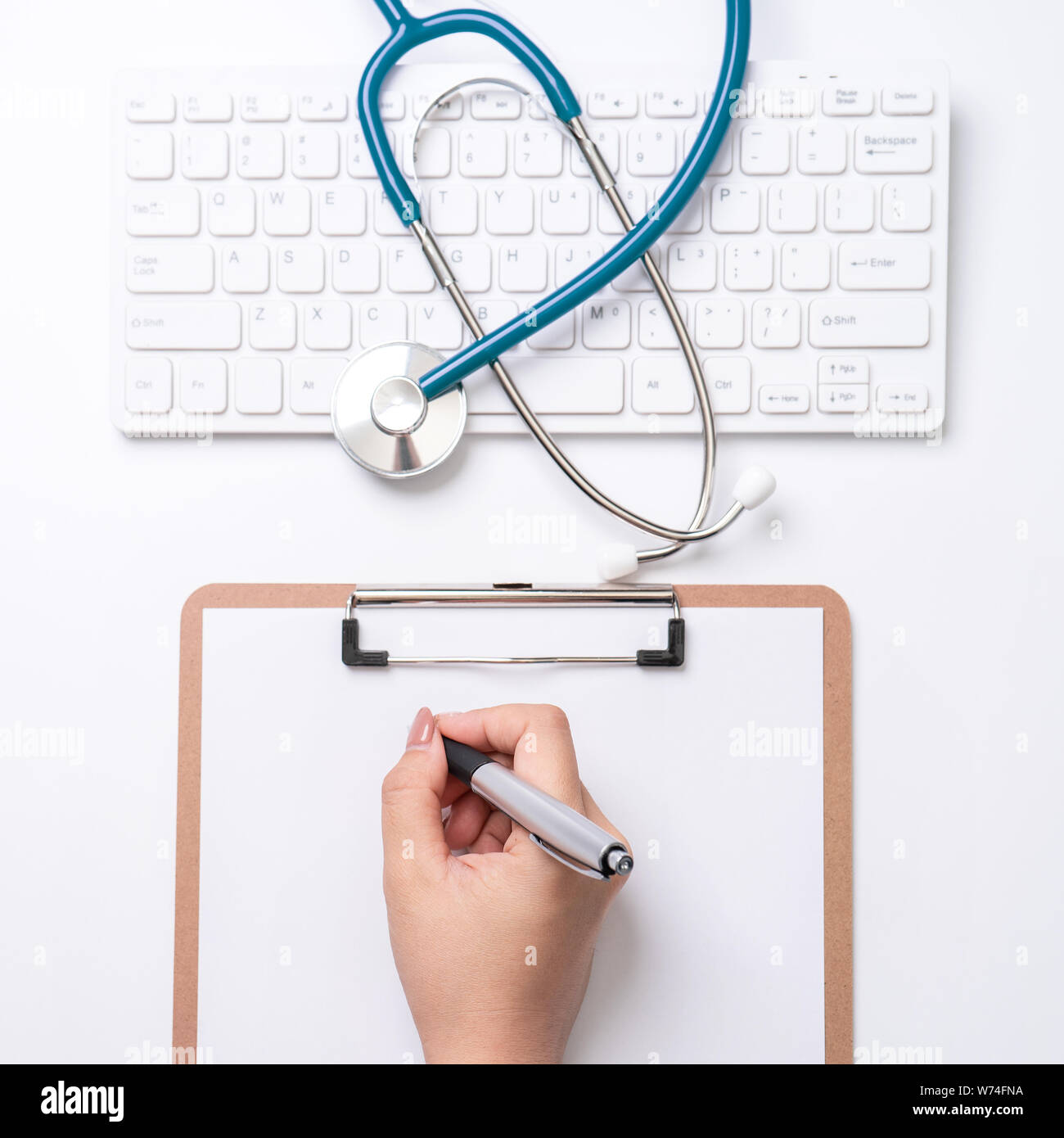 Female doctor writing a medical record case over clipboard on white ...