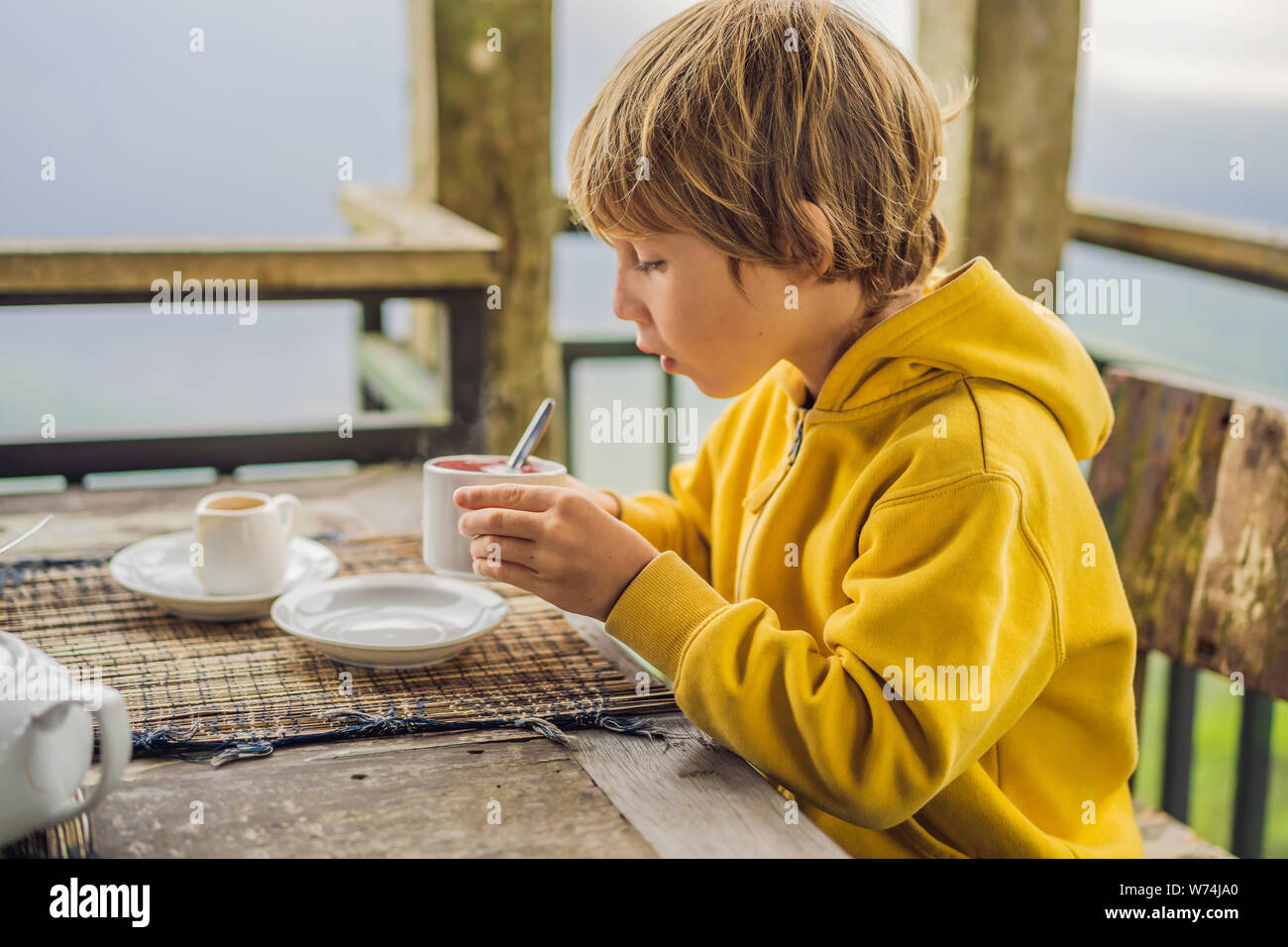 Boy drinking tea in a cafe in the mountains Stock Photo - Alamy