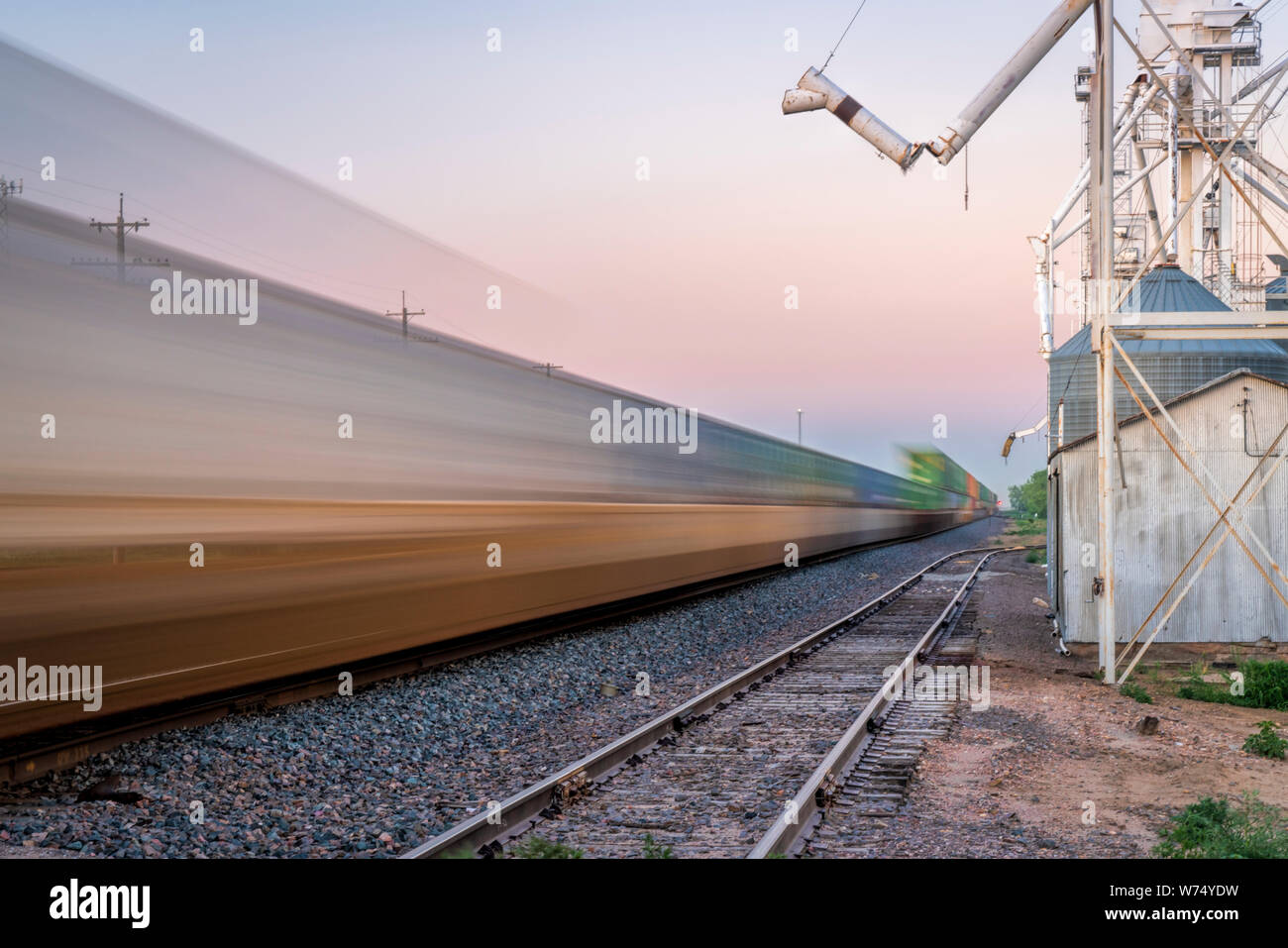 freight container train passing a rural town with grain elevator Stock ...