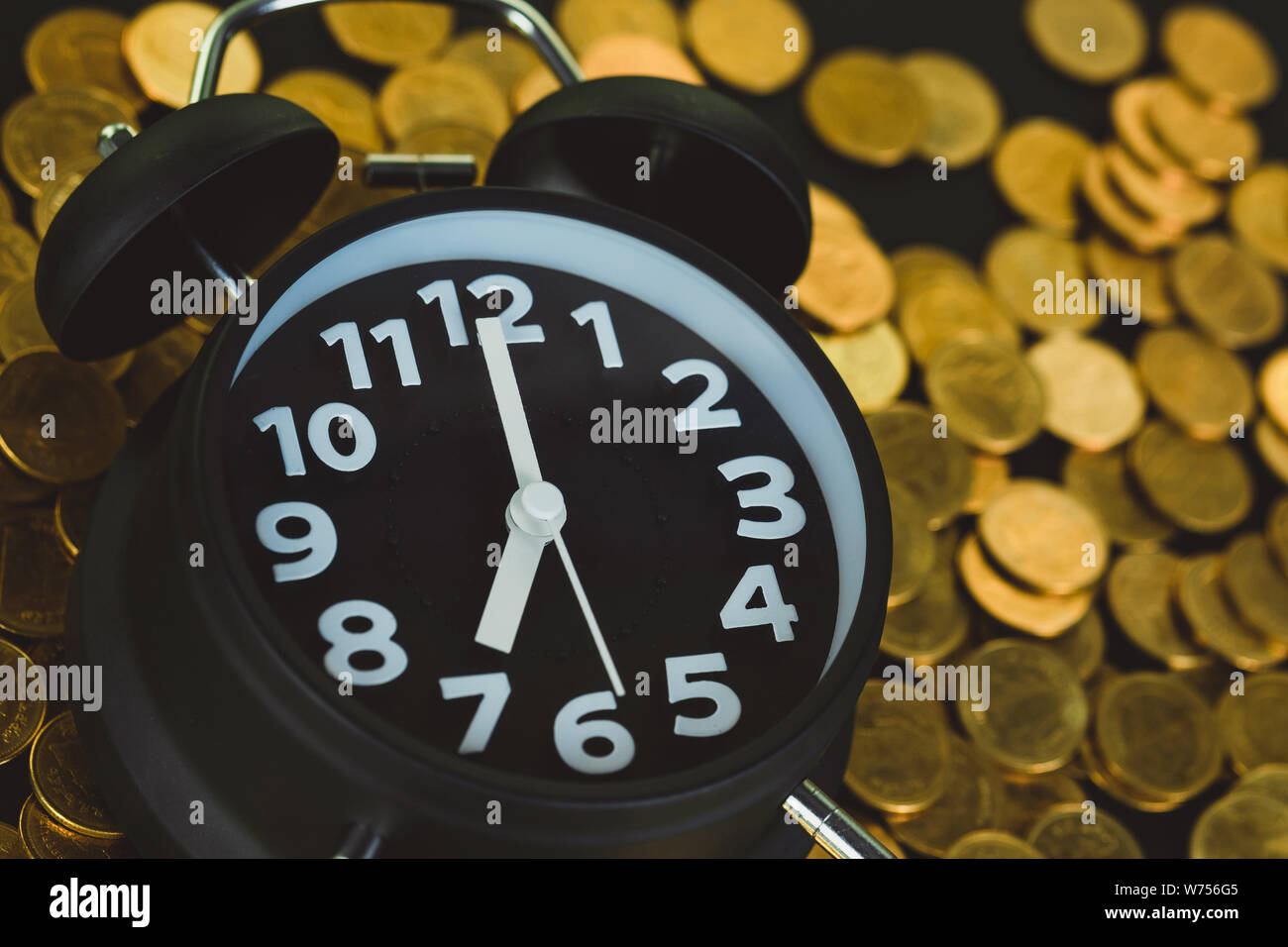 Alarm clock and coins stacks on working table, time for savings money ...