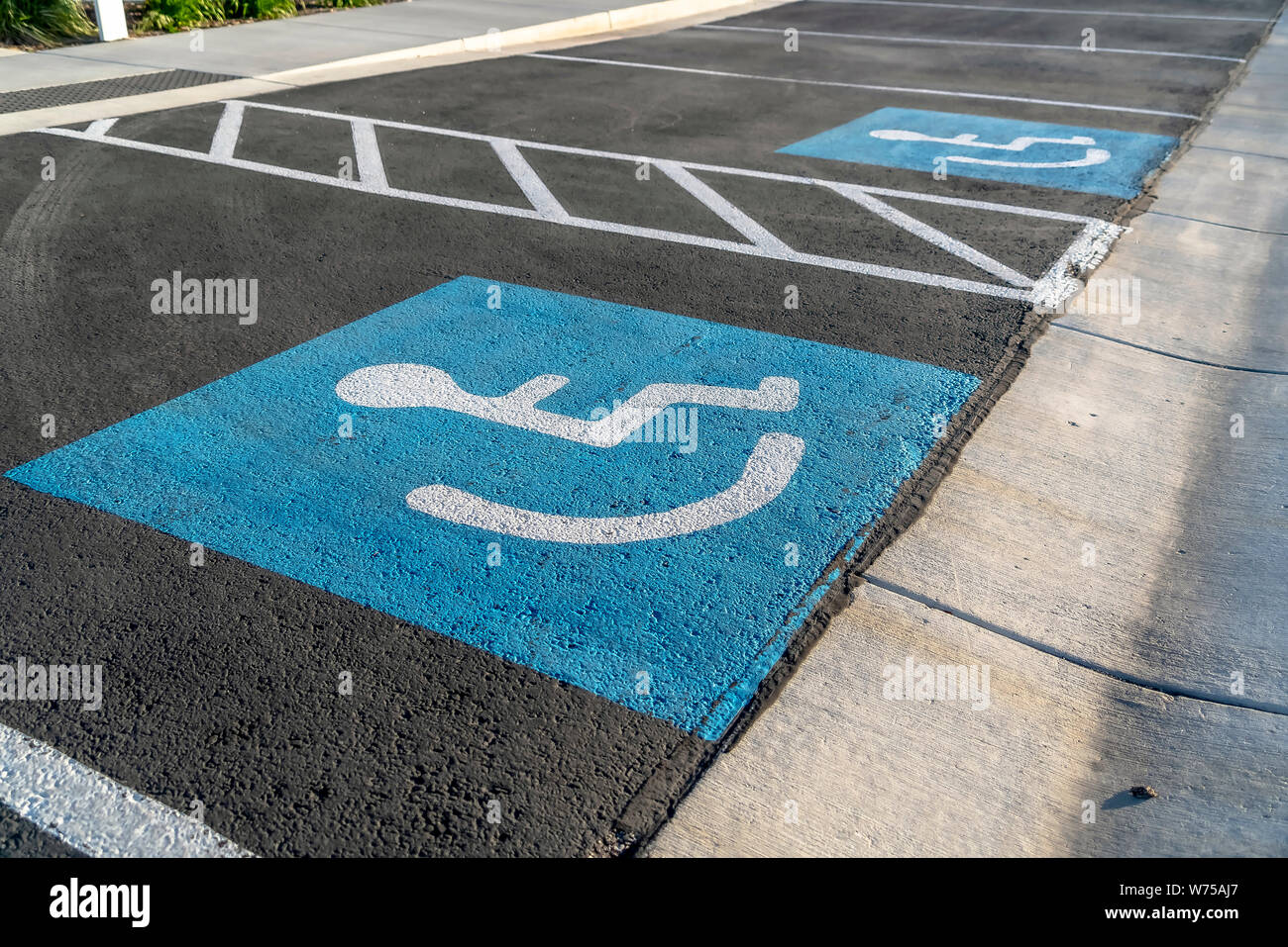 Close up of a person on a wheelchair icon painted on the black pavement ...