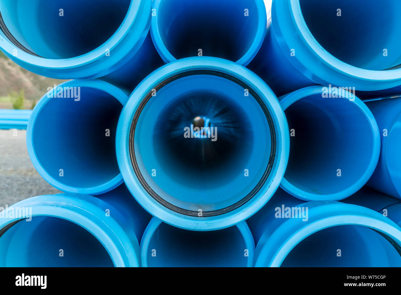 Close up view of the holes of long light blue pipes at a construction ...