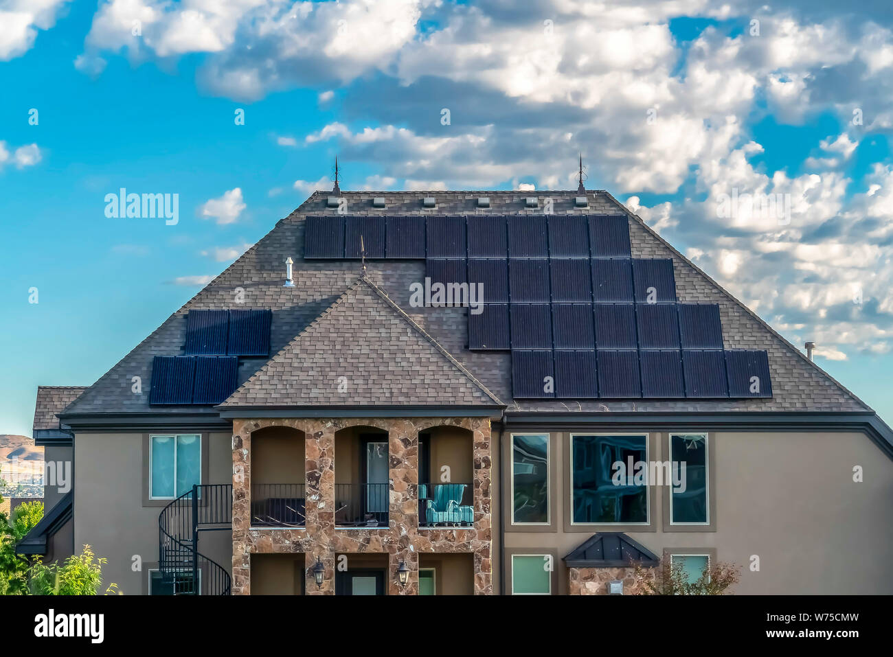 Facade of a solar powered home with spiral staircase going up to the ...