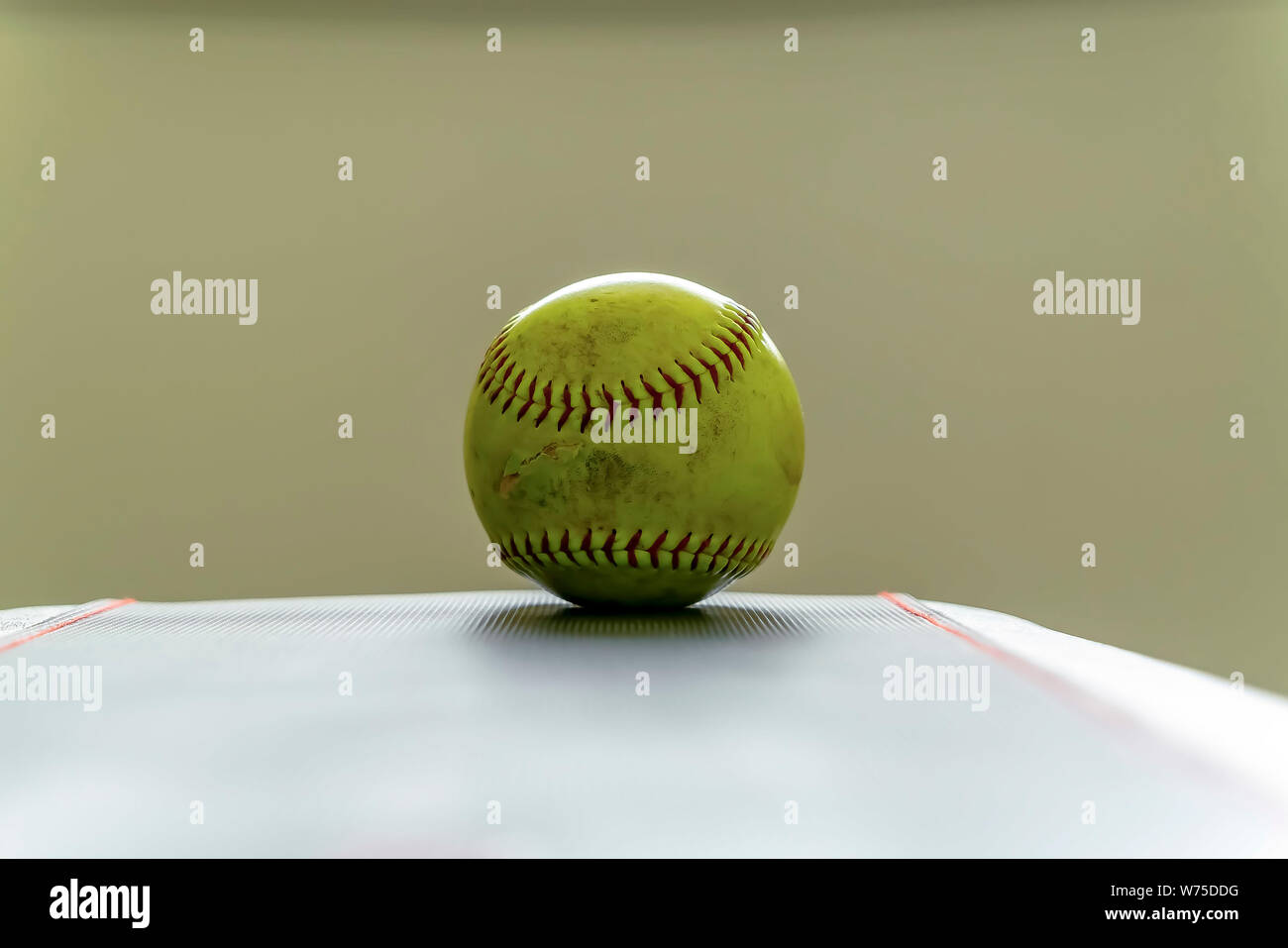 Dirty softball on top of a white table and isolated against a white ...