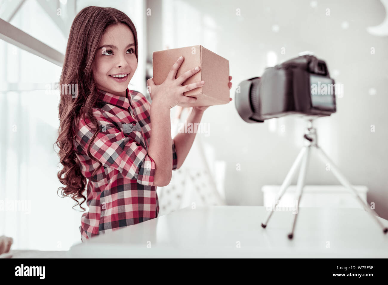 Delighted nice curious girl shaking the box Stock Photo - Alamy