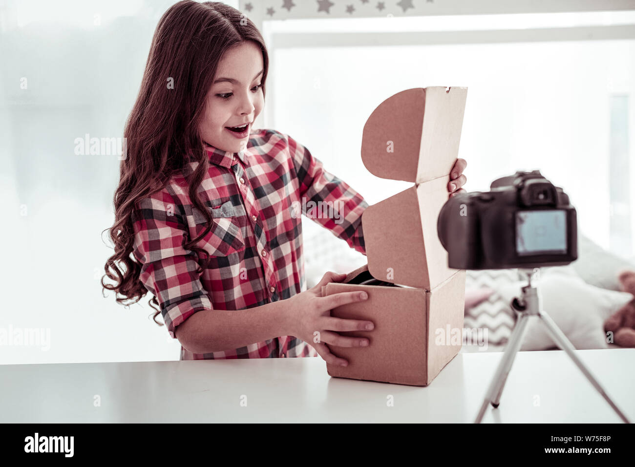 Happy excited girl looking into the box Stock Photo - Alamy