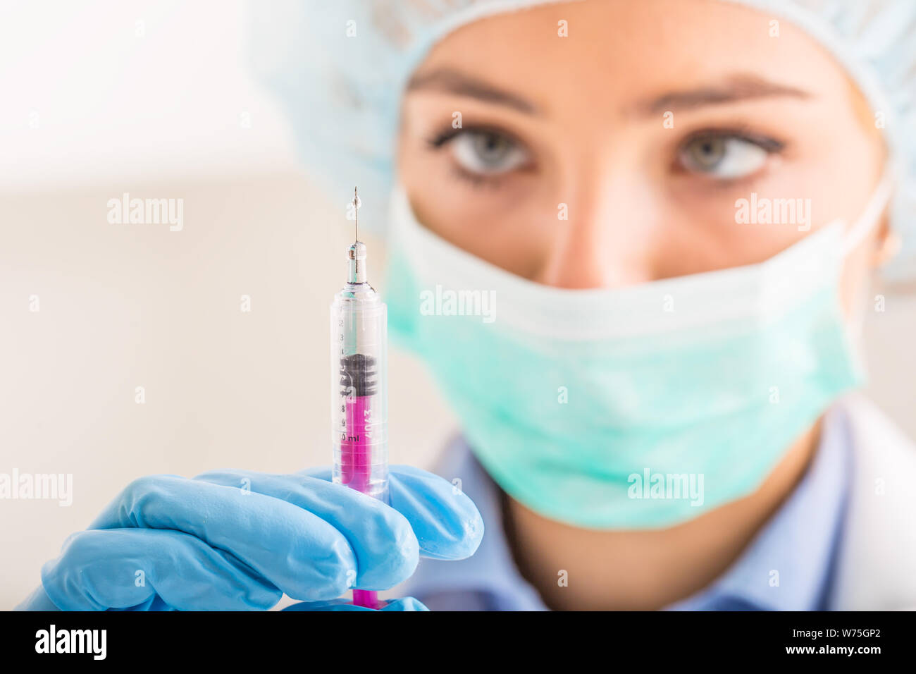 Female doctor working with syringe needle and ampoule of medicine. A ...