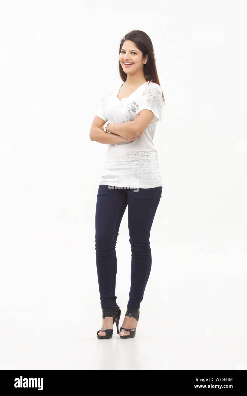 Young woman standing with her arms crossed Stock Photo - Alamy