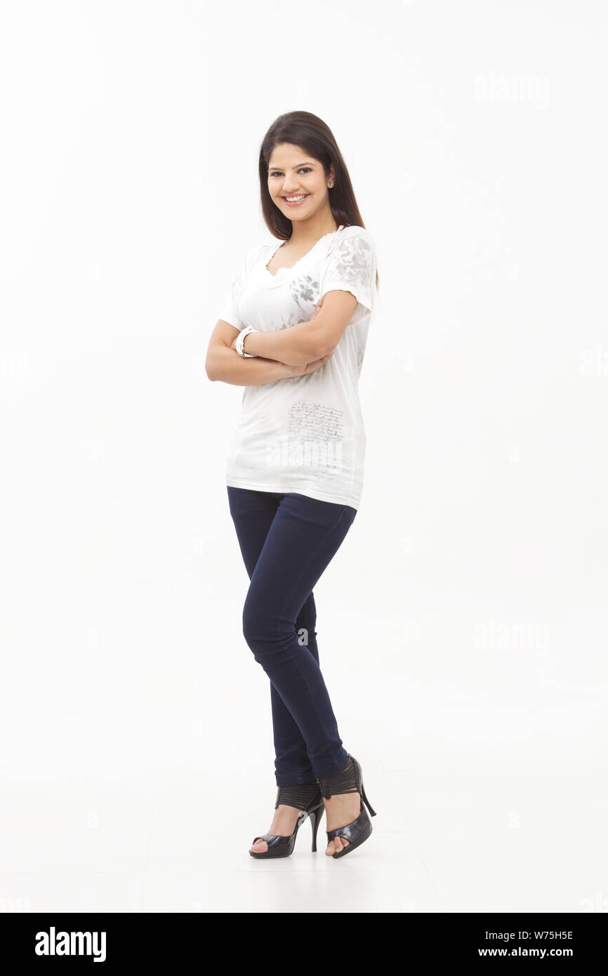 Young woman standing with her arms crossed Stock Photo - Alamy