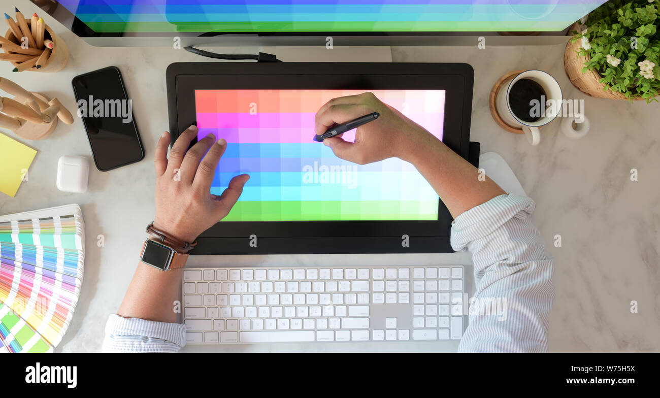 Young male graphic designer working on colour selection with colour ...