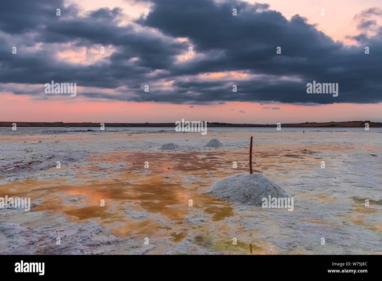 Salt mining on the lake during sunset Stock Photo - Alamy