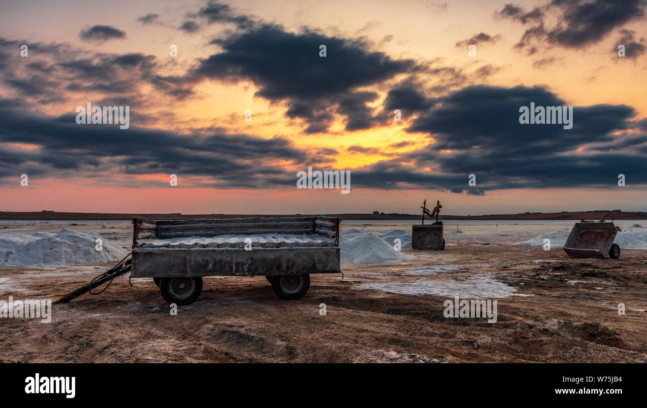 Salt mining on the lake during sunset Stock Photo - Alamy
