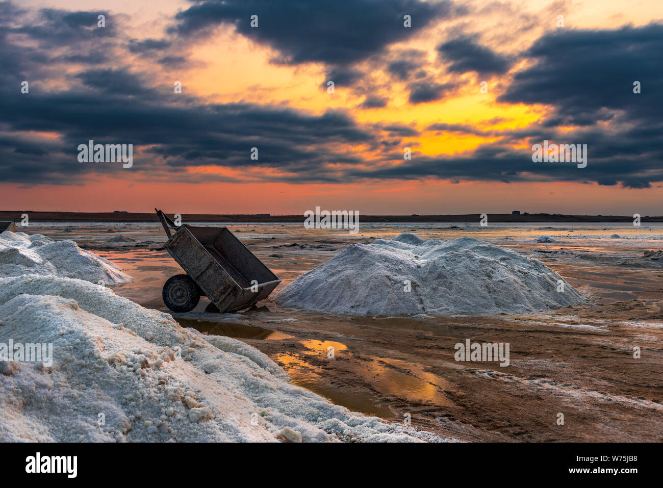 Salt mining on the lake during sunset Stock Photo - Alamy