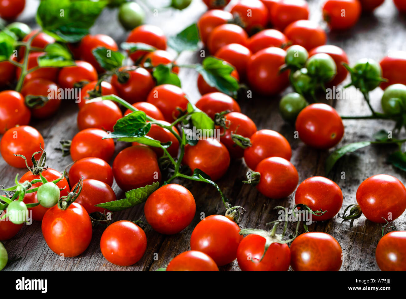 Small tomatoes called cherry tomato, close-up on wooden table, farm ...