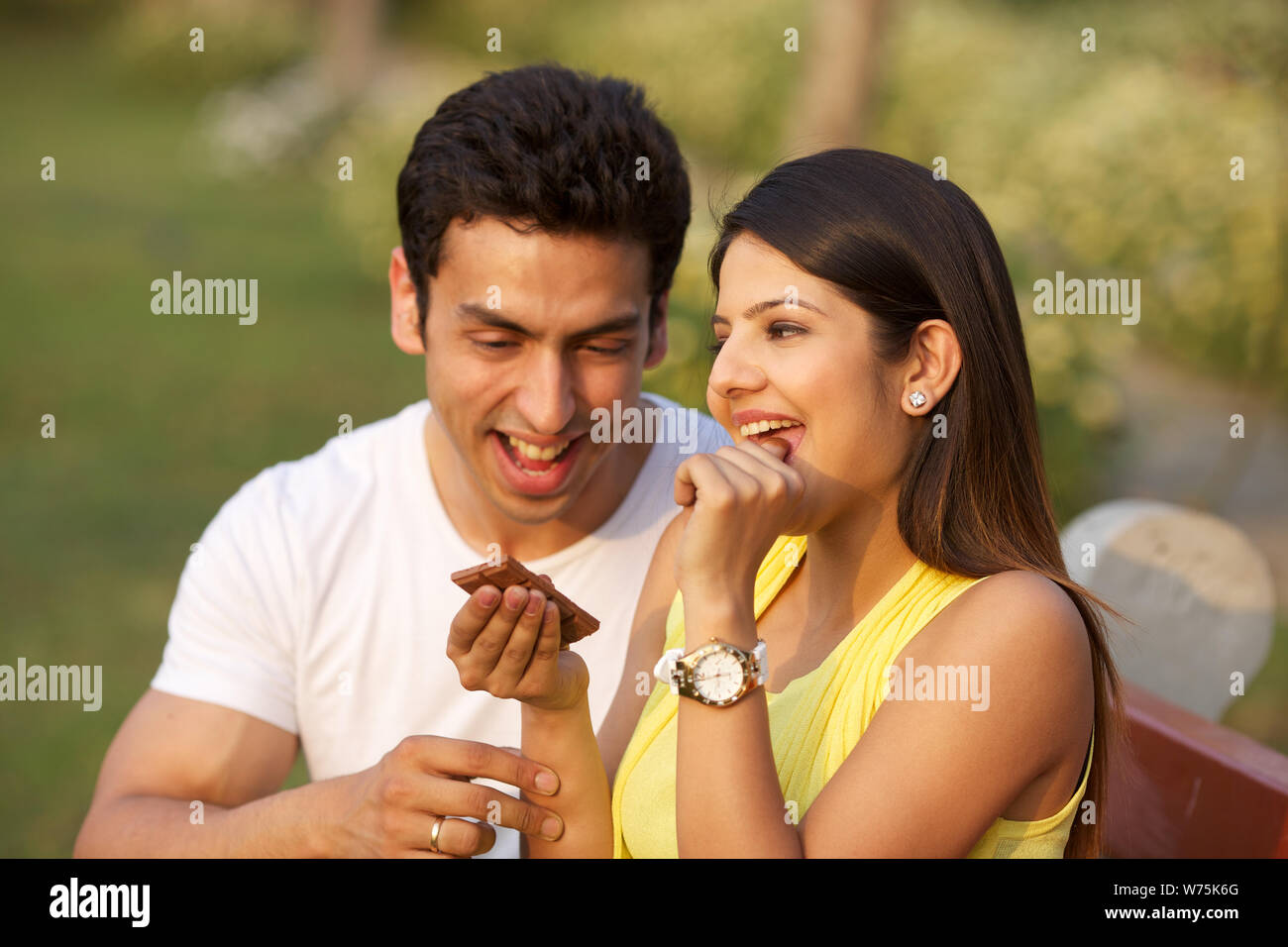 Young couple eating a chocolate bar Stock Photo - Alamy