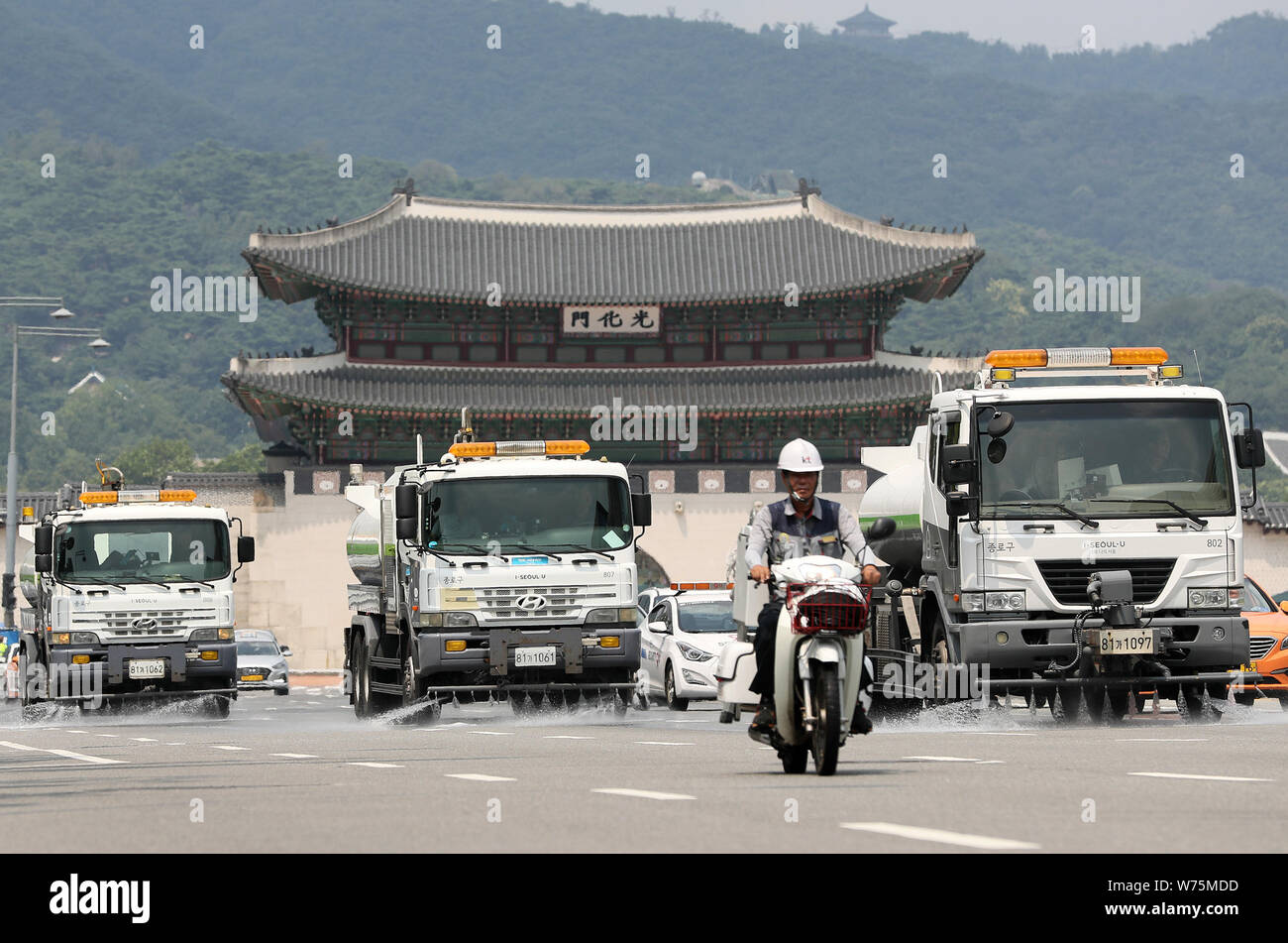 05th Aug, 2019. Fighting toasting heat Vehicles spray water on a street in downtown Seoul to ...